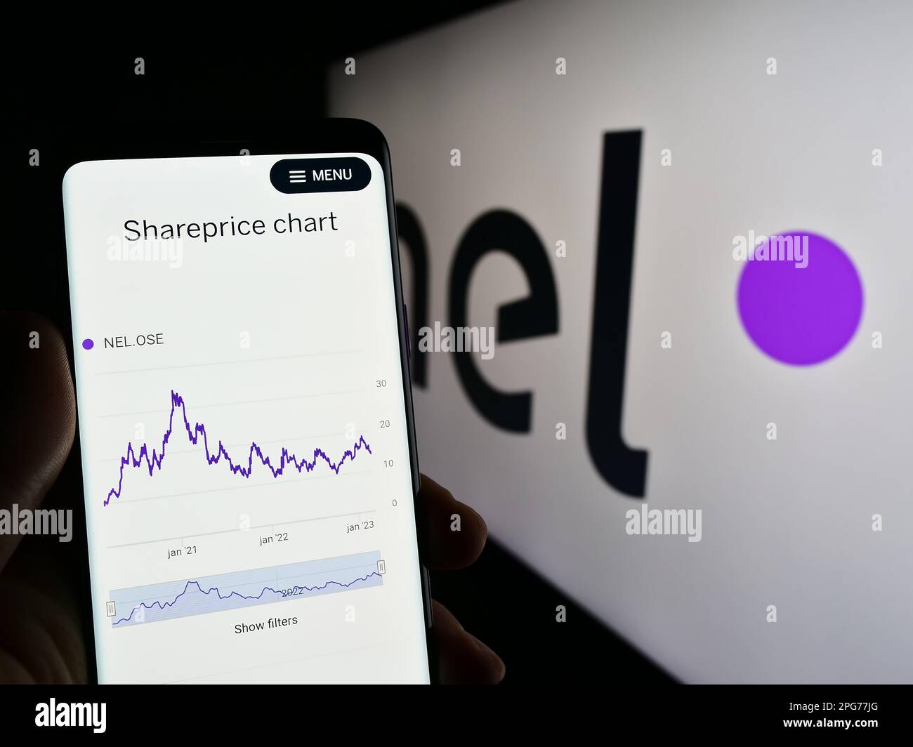 Person holding cellphone with website of Norwegian hydrogen company Nel ...