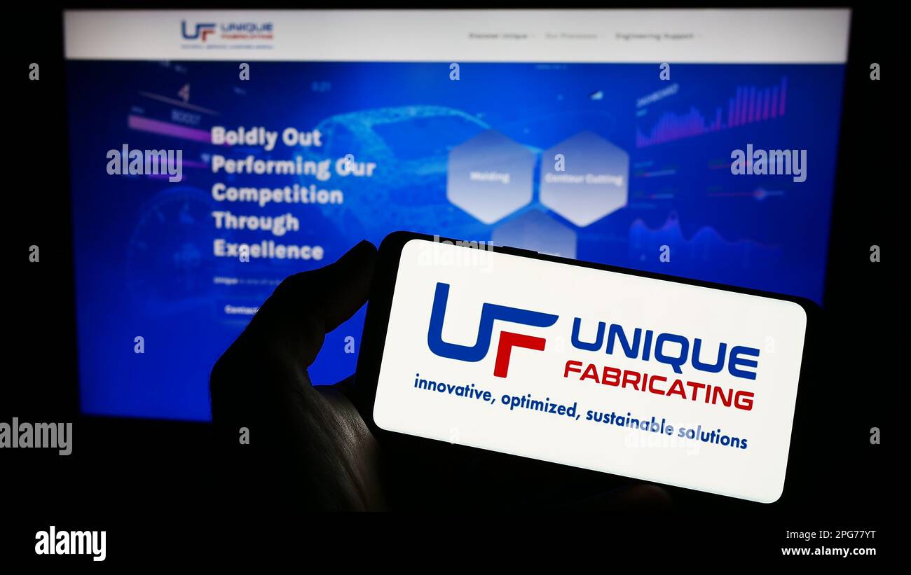 Person holding mobile phone with logo of US manufacturing company ...