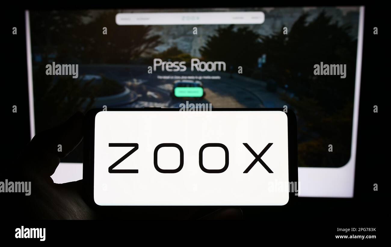 Person holding smartphone with logo of US autonomous vehicle company ...