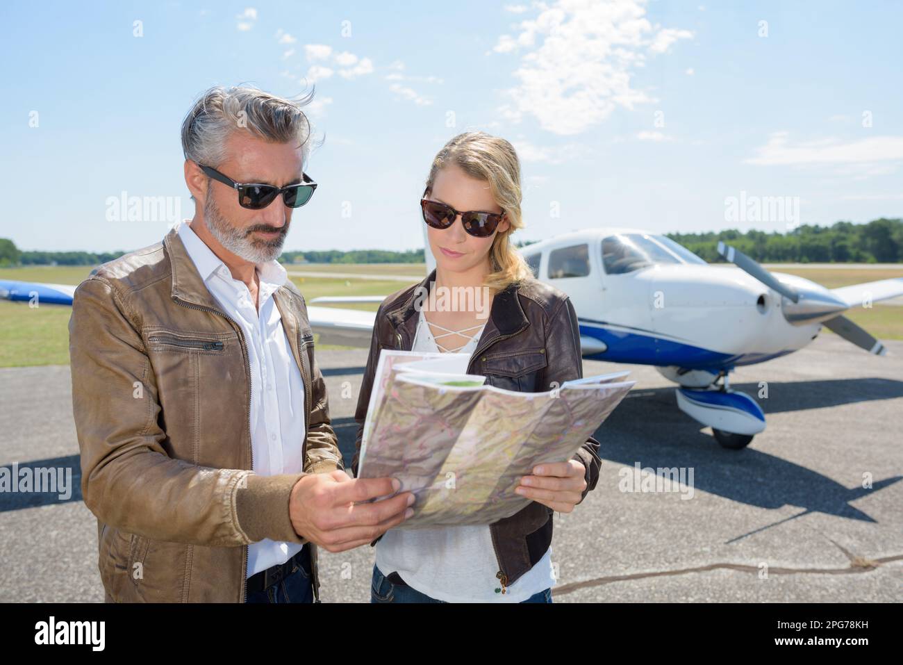 two modern aircraft engineers looking at map Stock Photo - Alamy