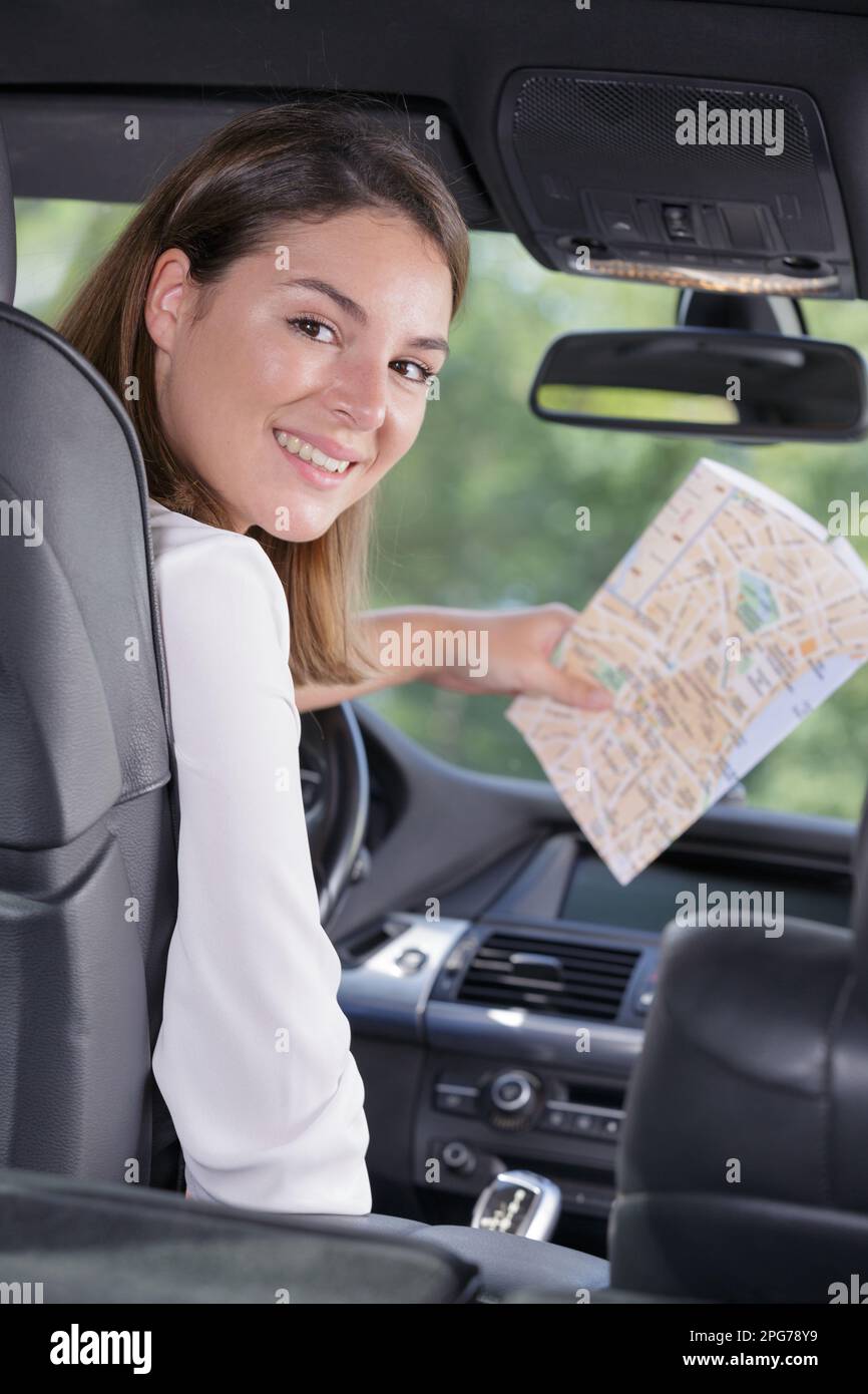 young woman driving a car and looking at the map Stock Photo - Alamy