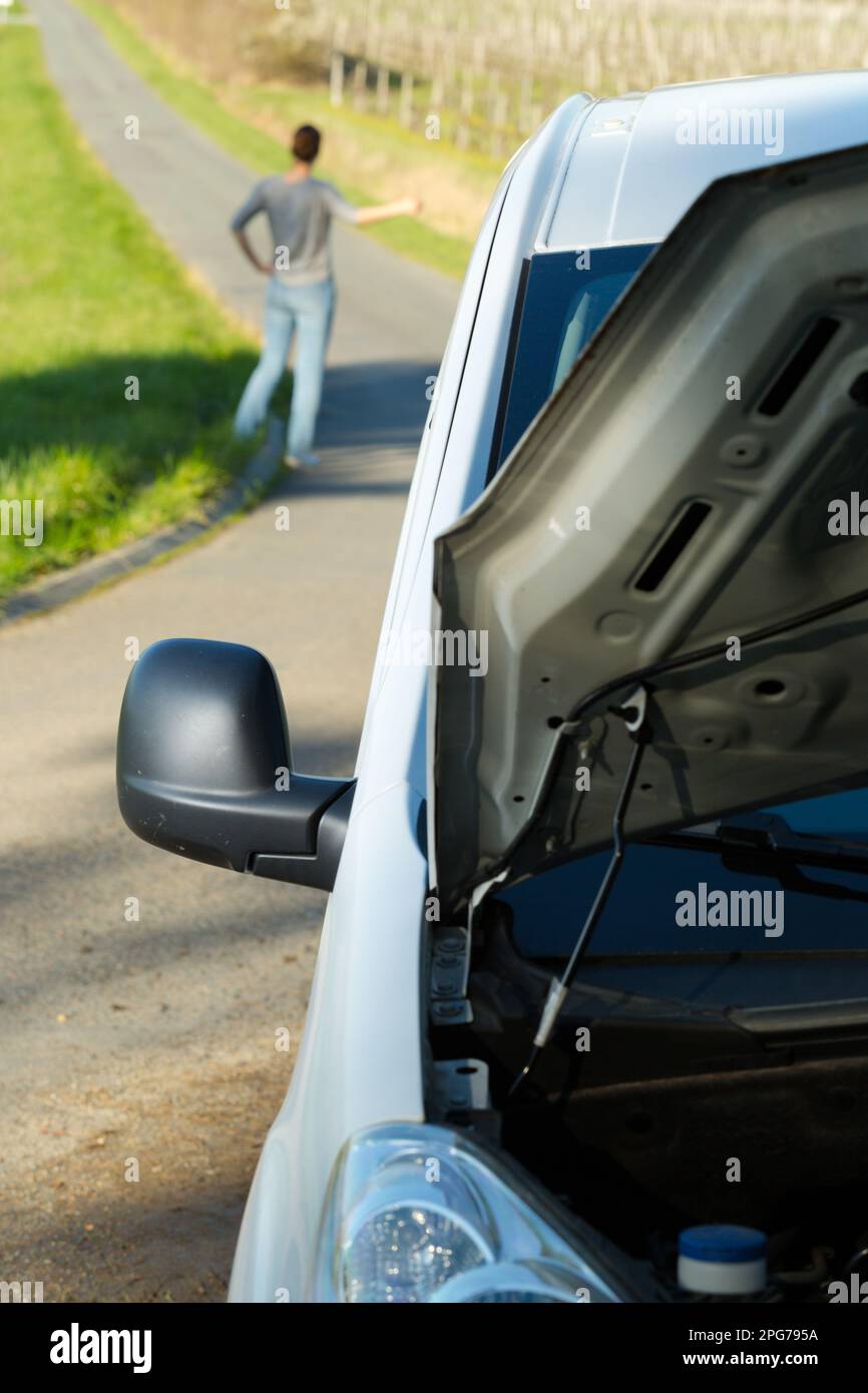 person thumbing a lift after car has broken down Stock Photo - Alamy
