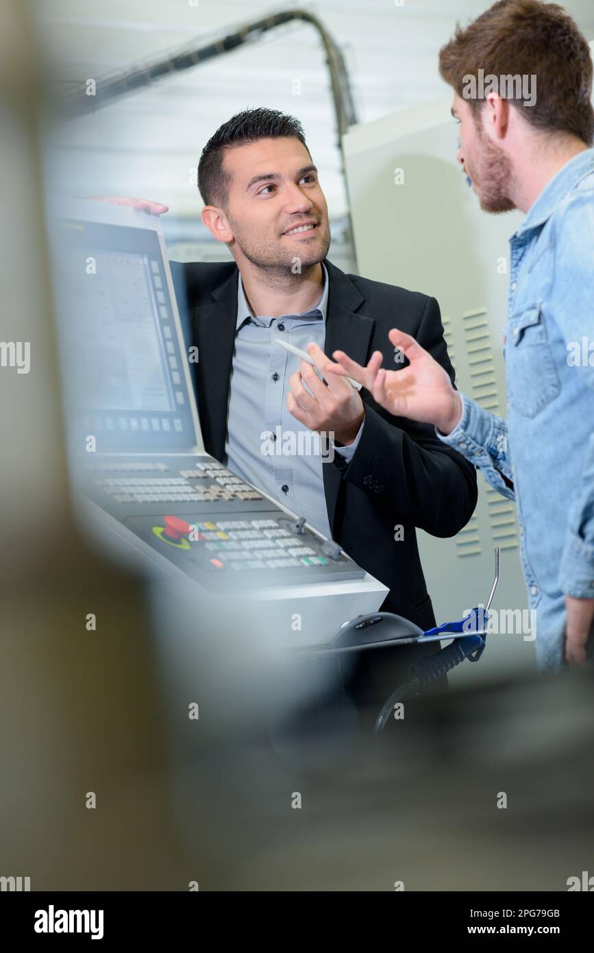 man and apprentice watching printing machine Stock Photo - Alamy