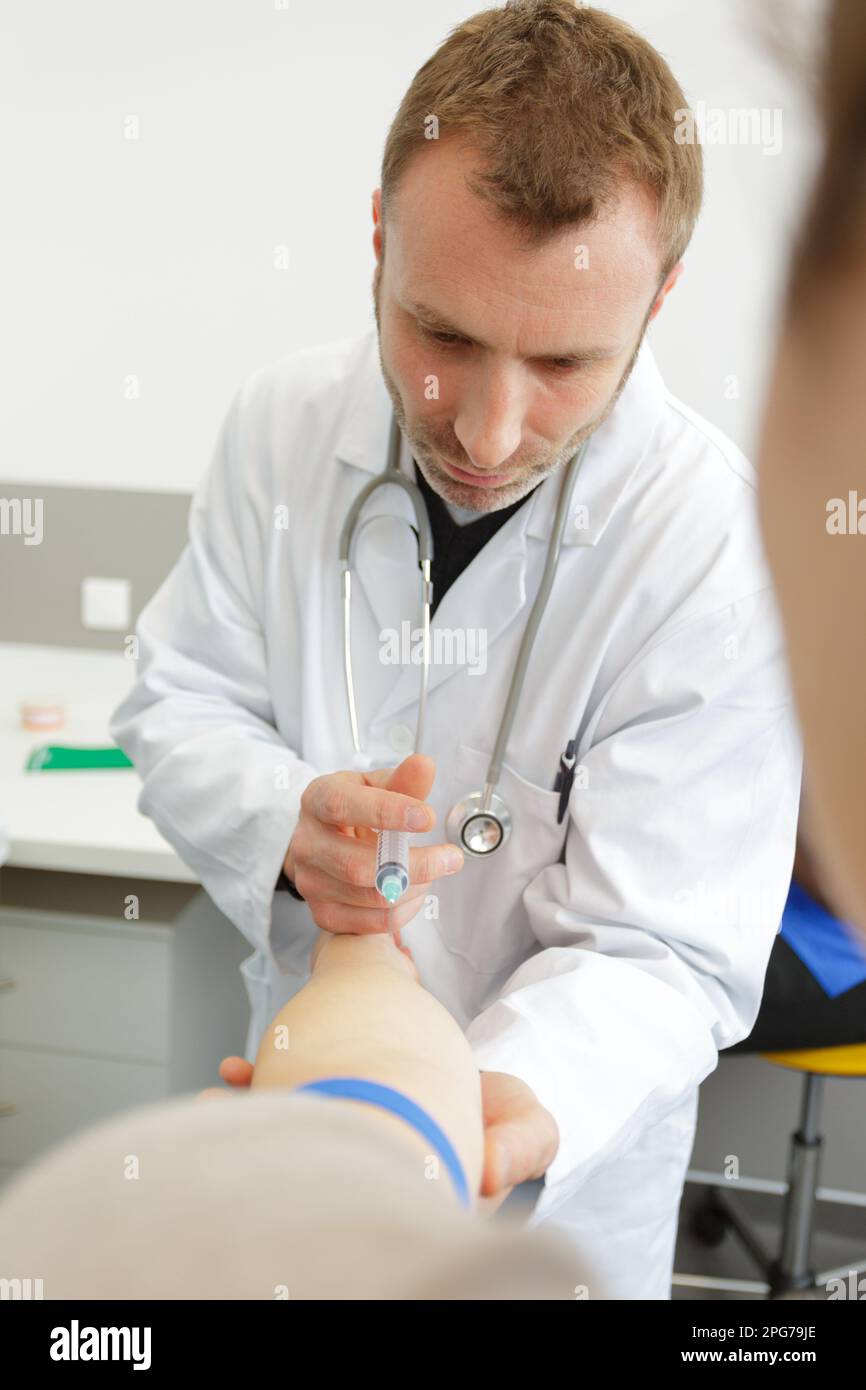man is getting an injection with a syringe at hospital Stock Photo - Alamy