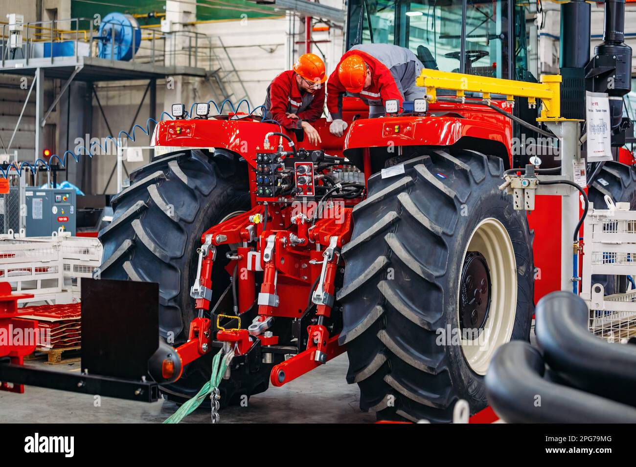 Industrial workers assembles agricultural tractor in workshop Stock ...