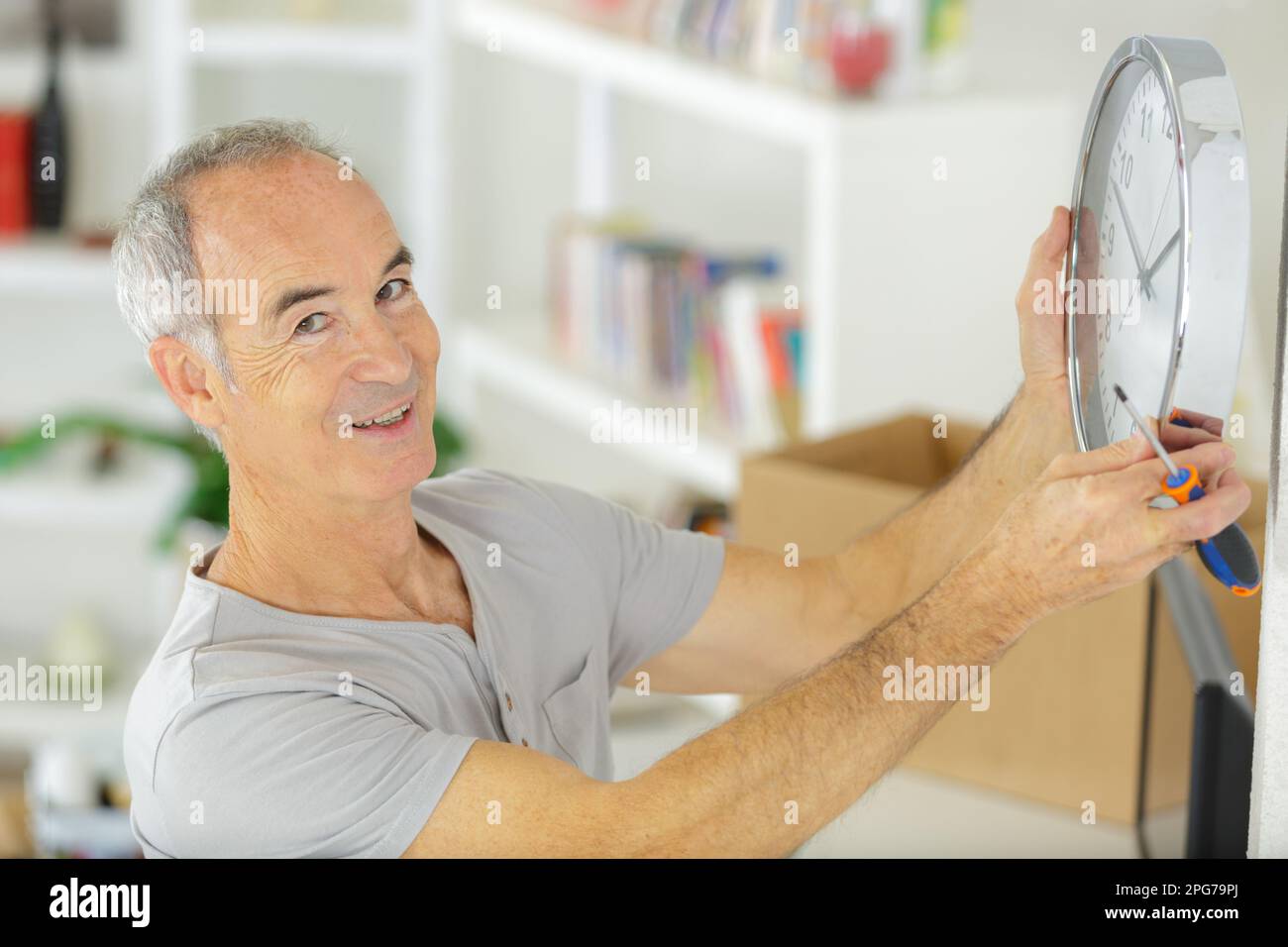 Handsome guy holding wall clock hi-res stock photography and images - Alamy