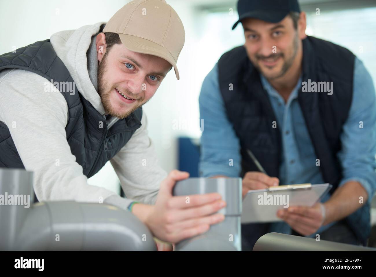 happy men during installation of pipes indoors Stock Photo - Alamy