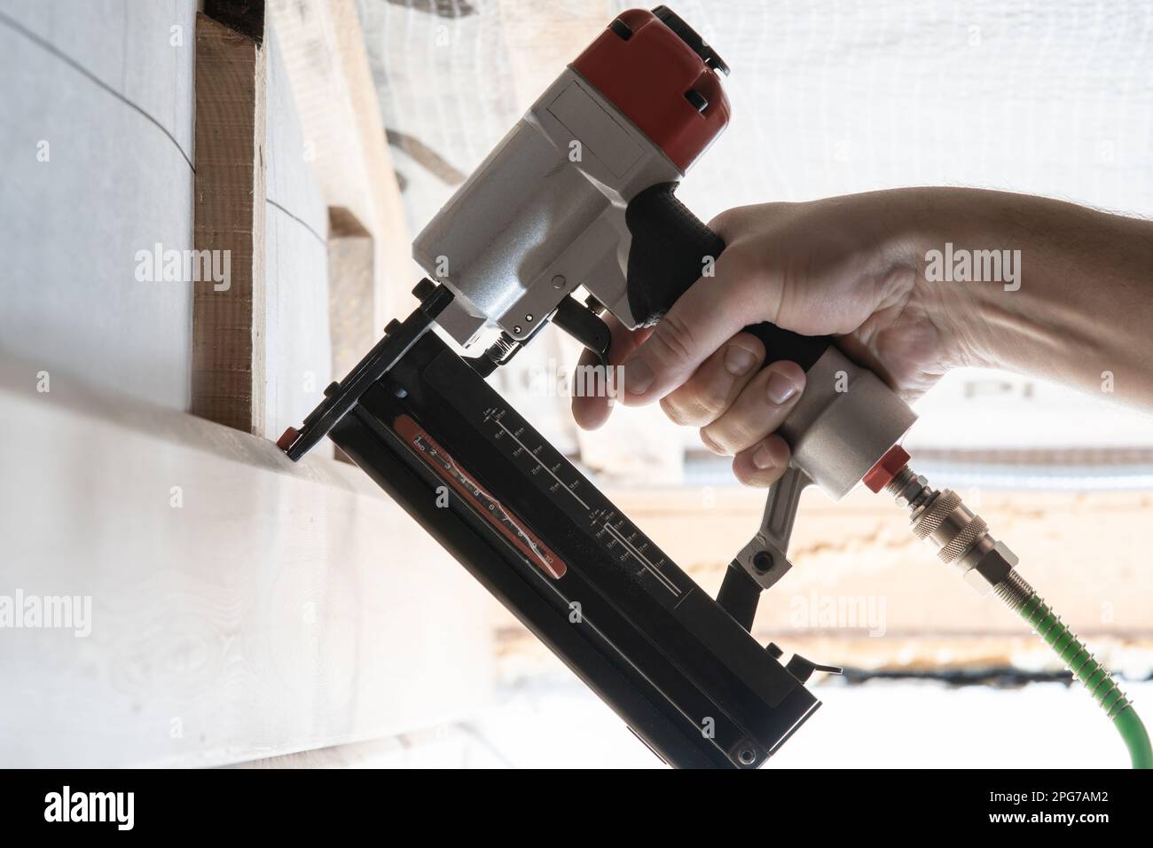 Cropped man hand hold pneumatic stapler nail gun for wooden timber ...