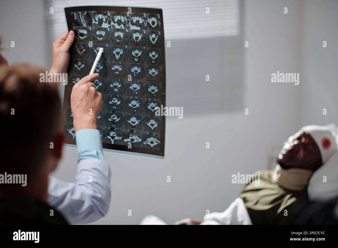 Close-up of doctor pointing at x-ray image of patient and examining it ...