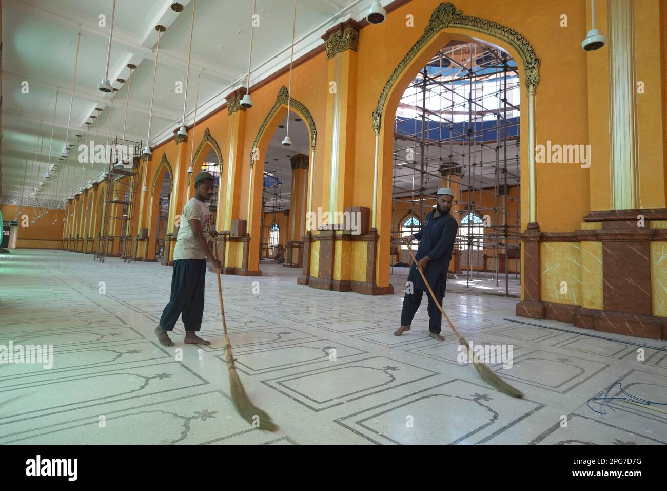 Workers clean an area after finishing repairing and paint work in a ...