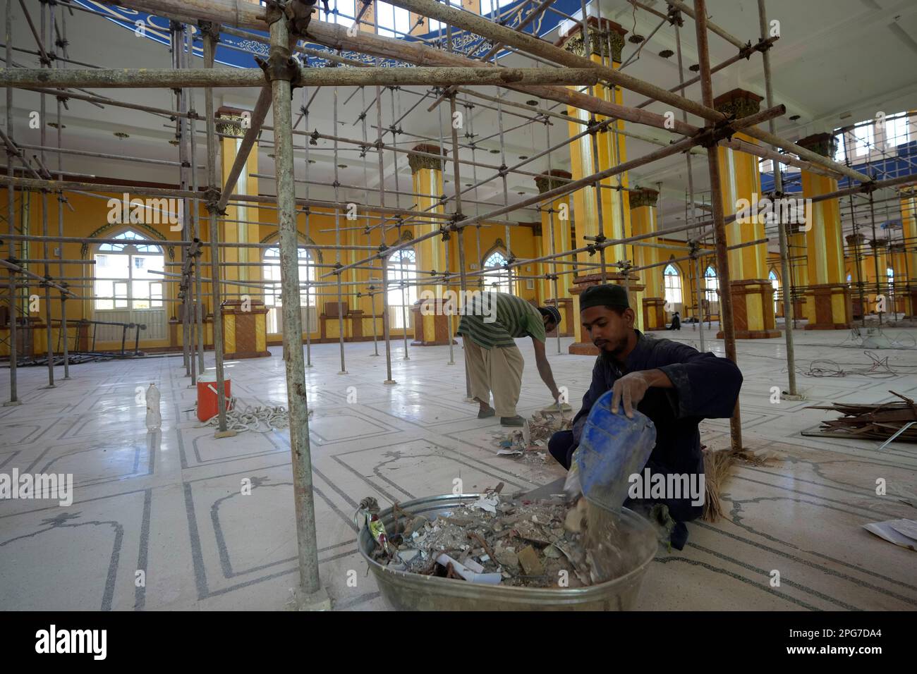 Workers clean an area after finishing repairing and paint work in a ...