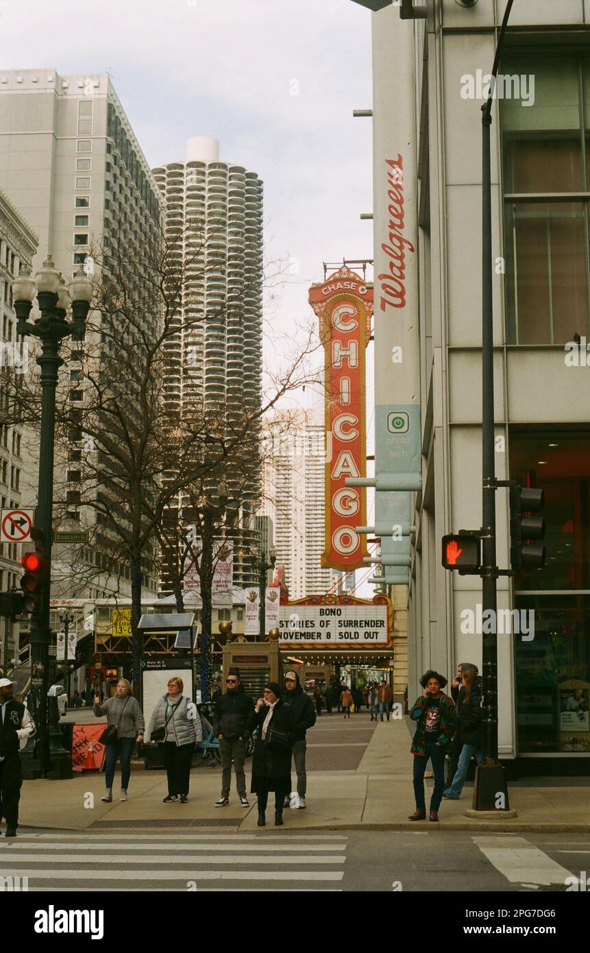 People walking on Chicago City streets with the Chicago Theatre in the ...