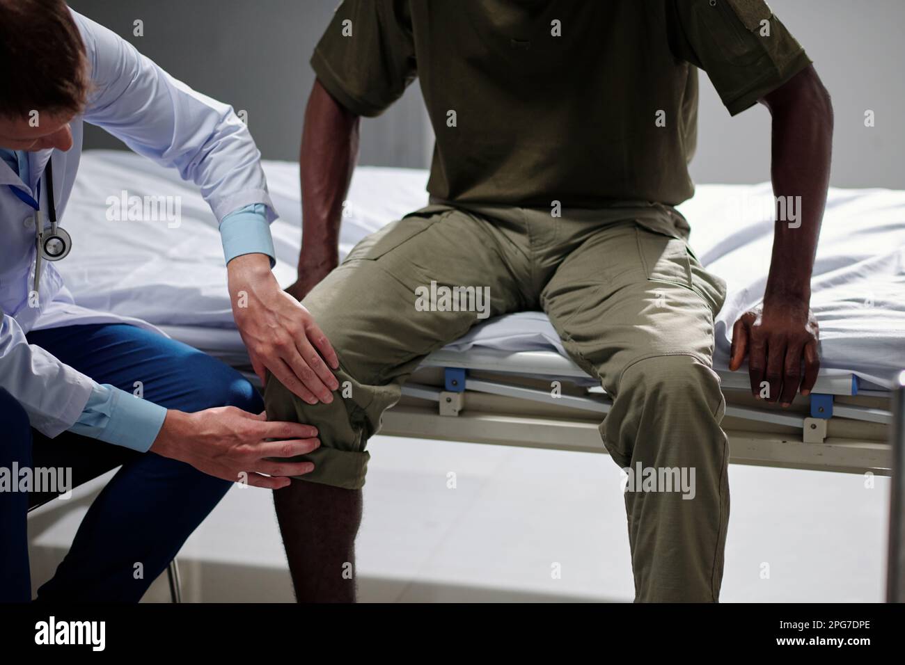 Close-up of doctor examining the leg of soldier in military hospital ...