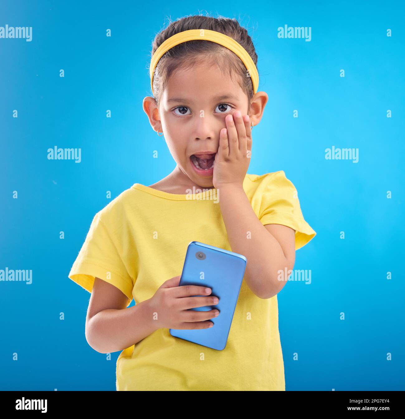 Phone, shock and portrait of child on blue background with wow, omg and ...