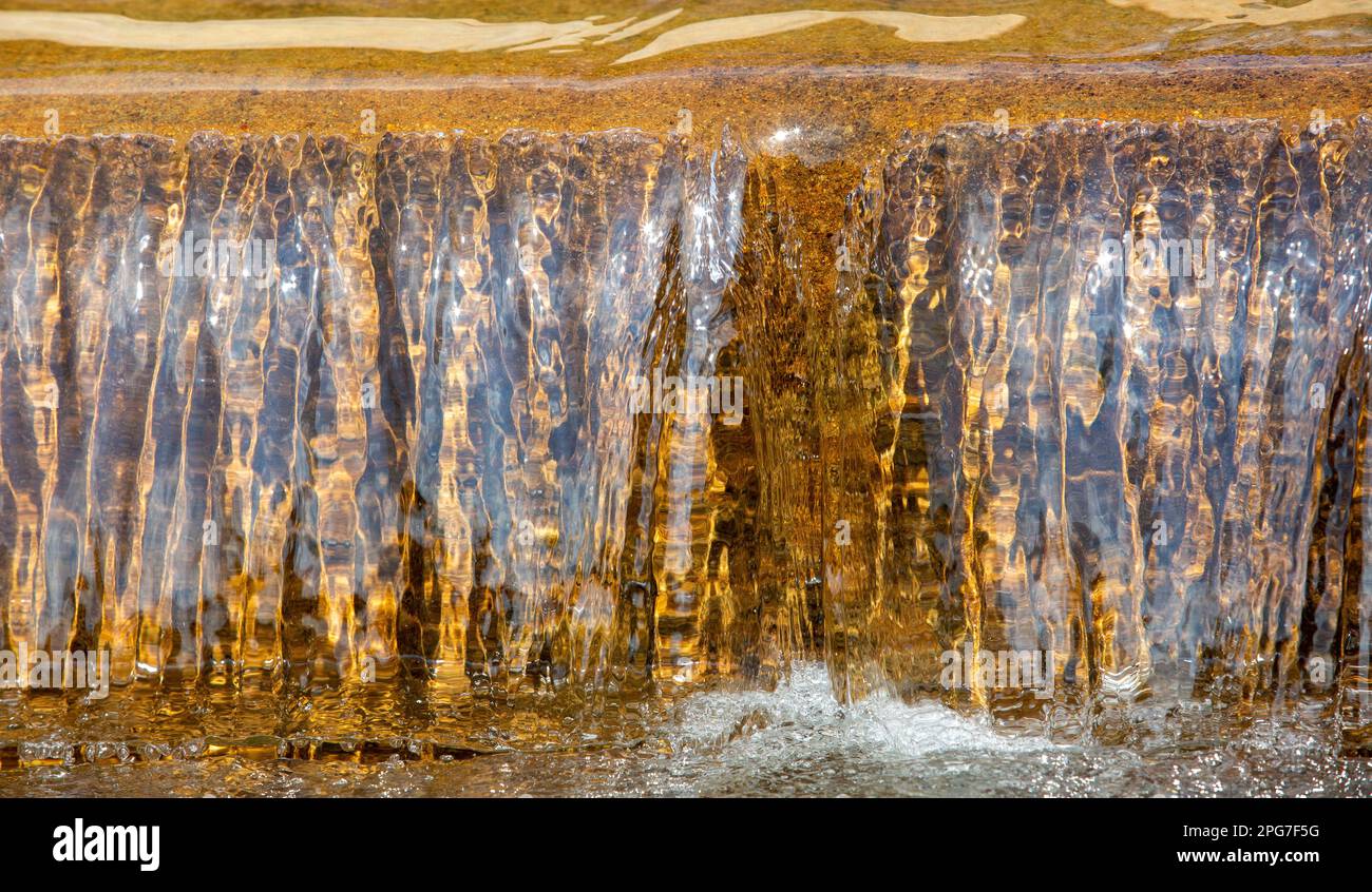 Crystal clear water from a mountain stream flowing over a weir Stock ...
