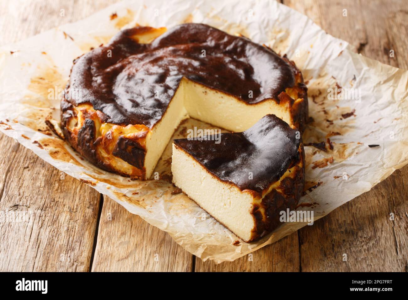 Traditional basque burnt cheesecake on a rustic wooden table closeup on ...