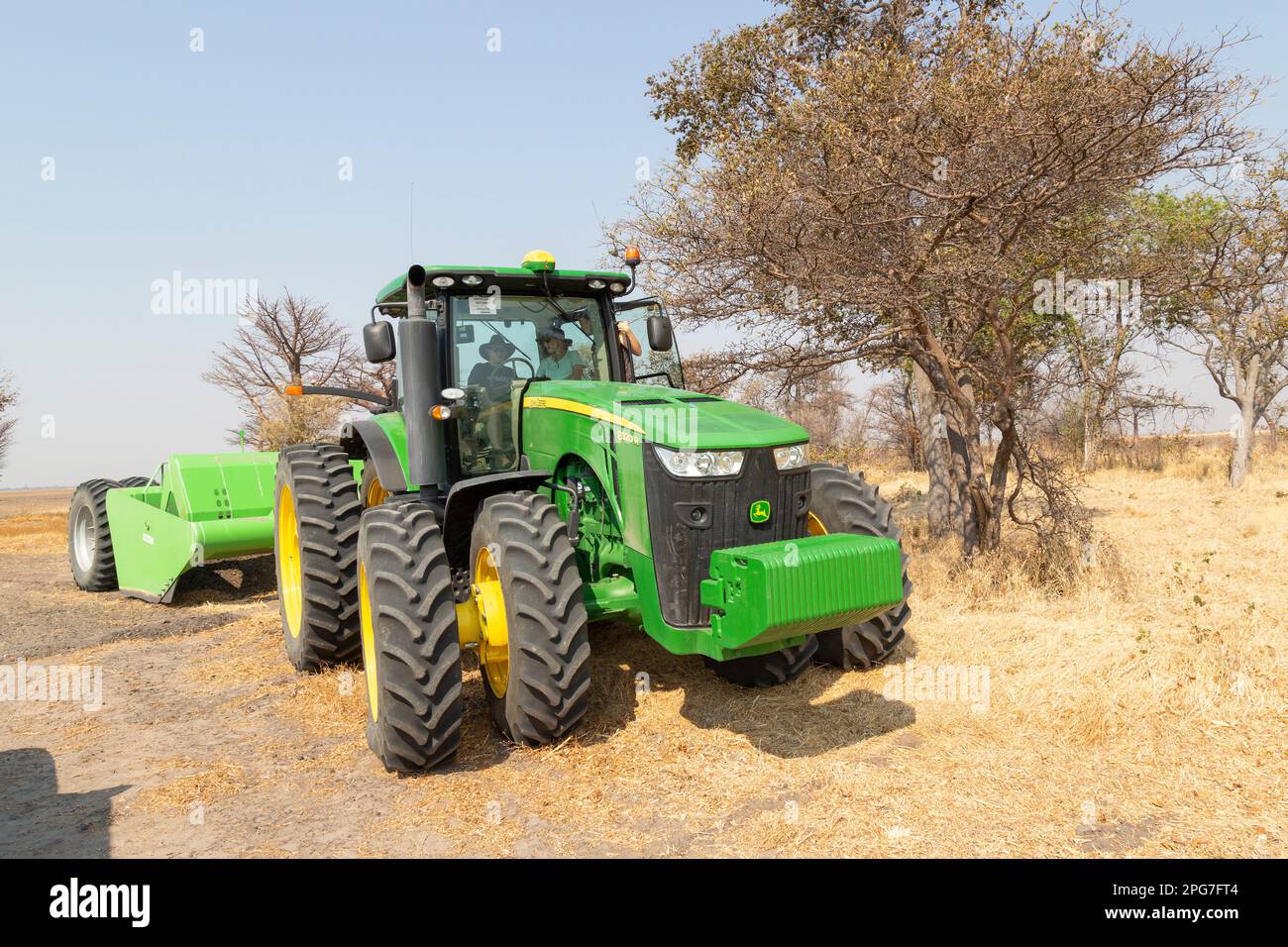 Large four wheel drive John Deere tractor with dam skoop used to level ...