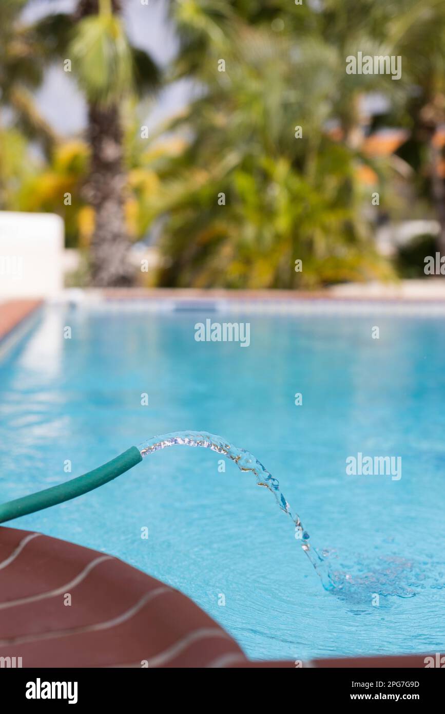 Water pipe filling up swimming pool closeup. Pool maintenance Stock ...