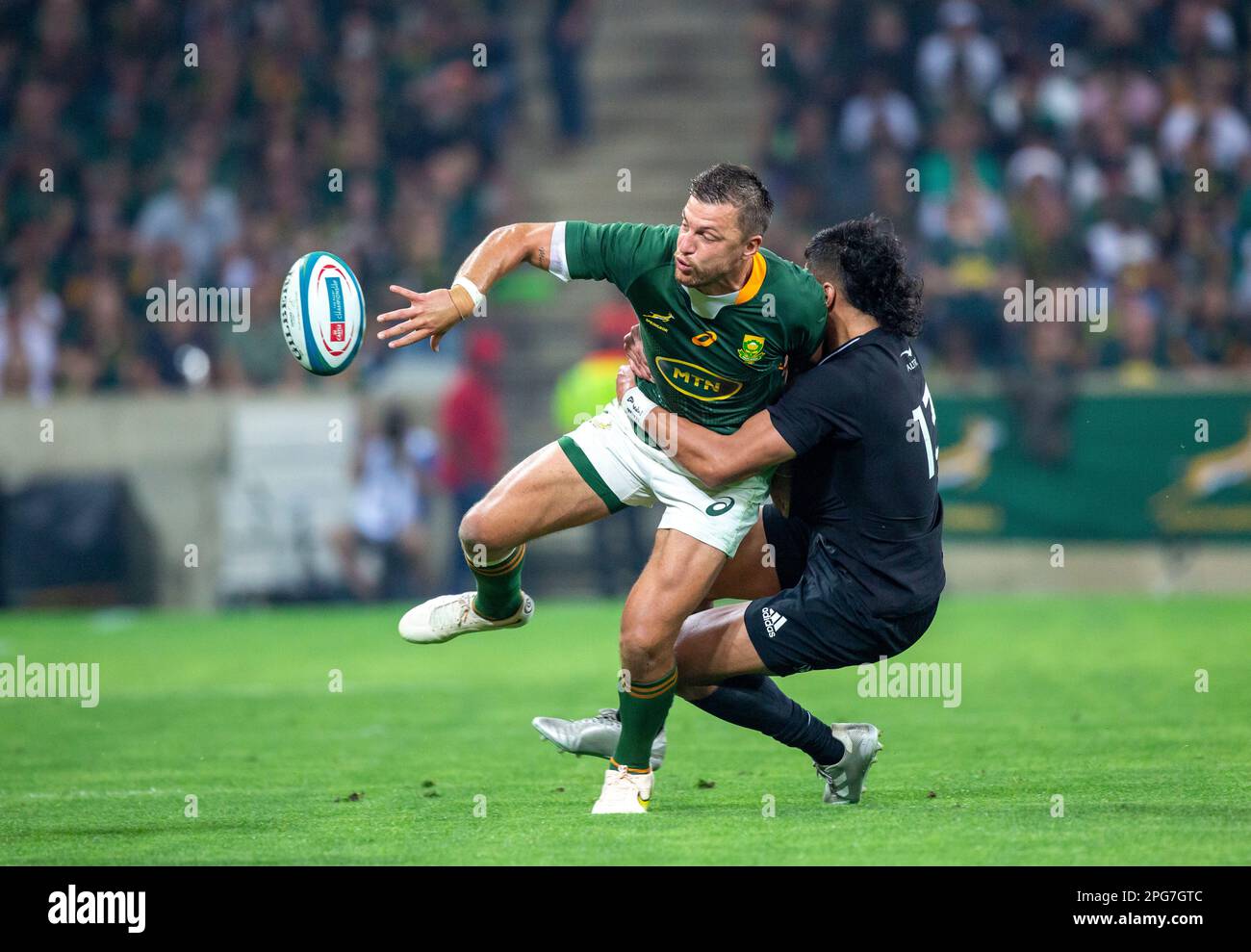 Handre Pollard releases the ball in a tackle by All Black Reiko Ioane ...