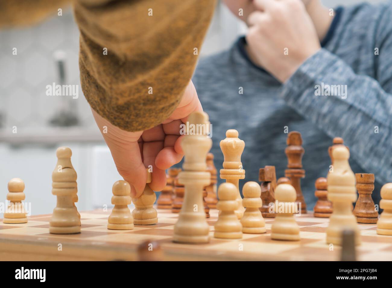 Close up cropped hand holding horse figure, playing chess on wooden ...