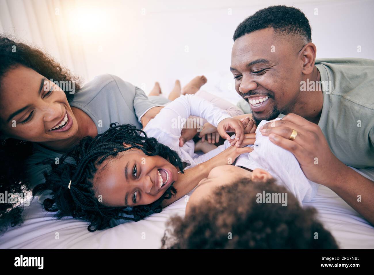 Laugh, tickle and morning with black family in bedroom for wake up ...