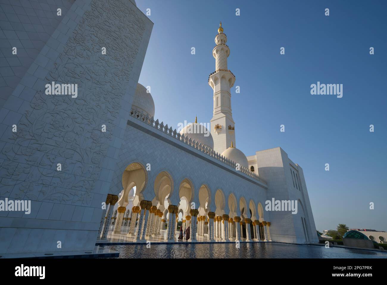 View of a tall minaret with reflecting pool, water feature. At the ...