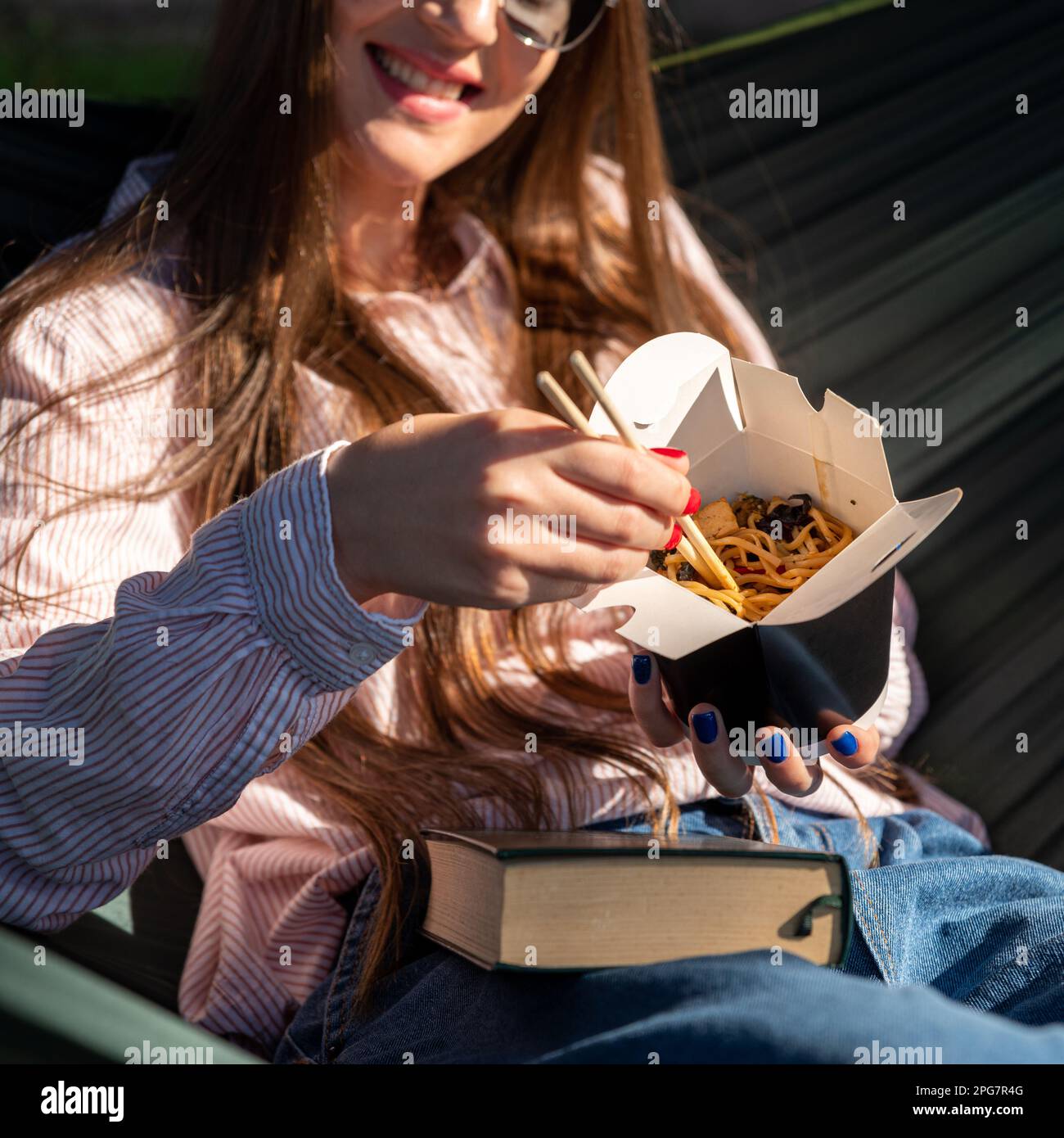 Close up takeout paper box with Noodles, Young woman eating Wok Noodles ...