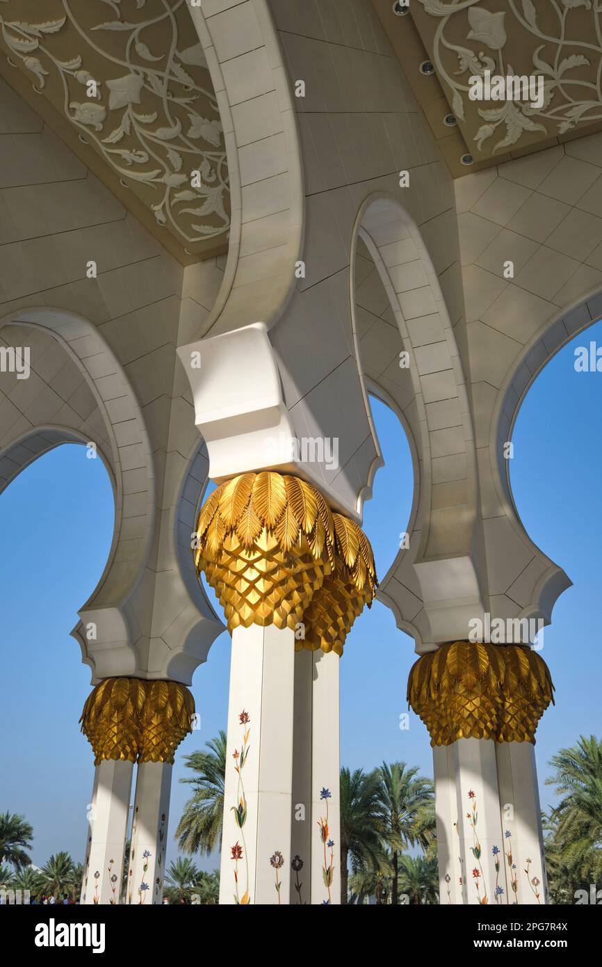 View of the walking, shaded portico with columns topped with painted ...
