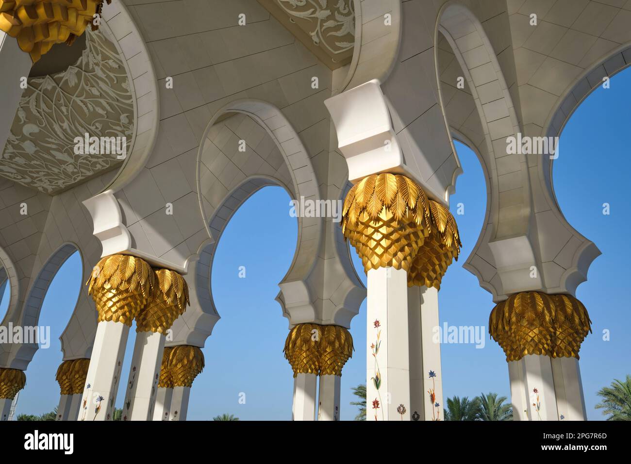 View of the walking, shaded portico with columns topped with painted ...