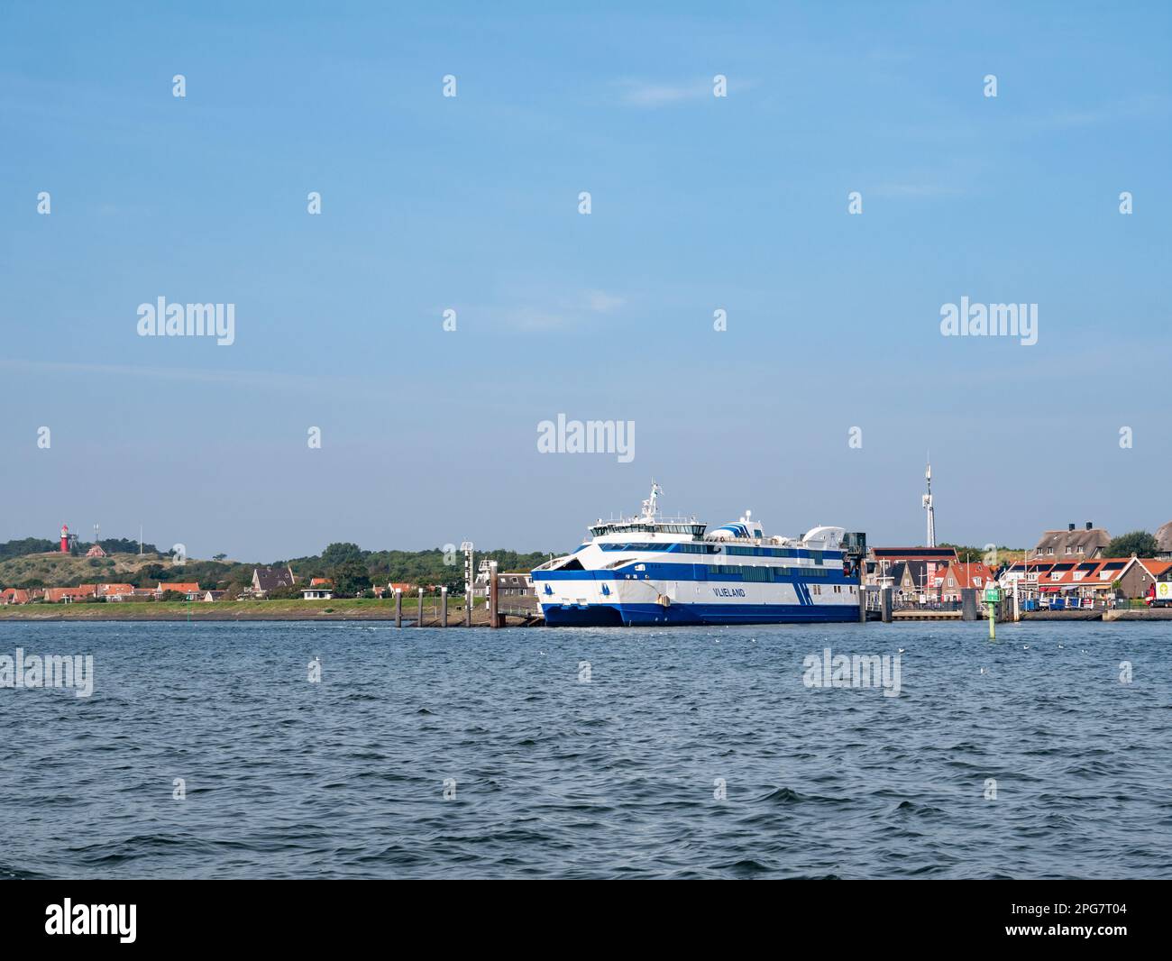 East-Vlieland village with ferry boat and lighthouse from Waddensea ...