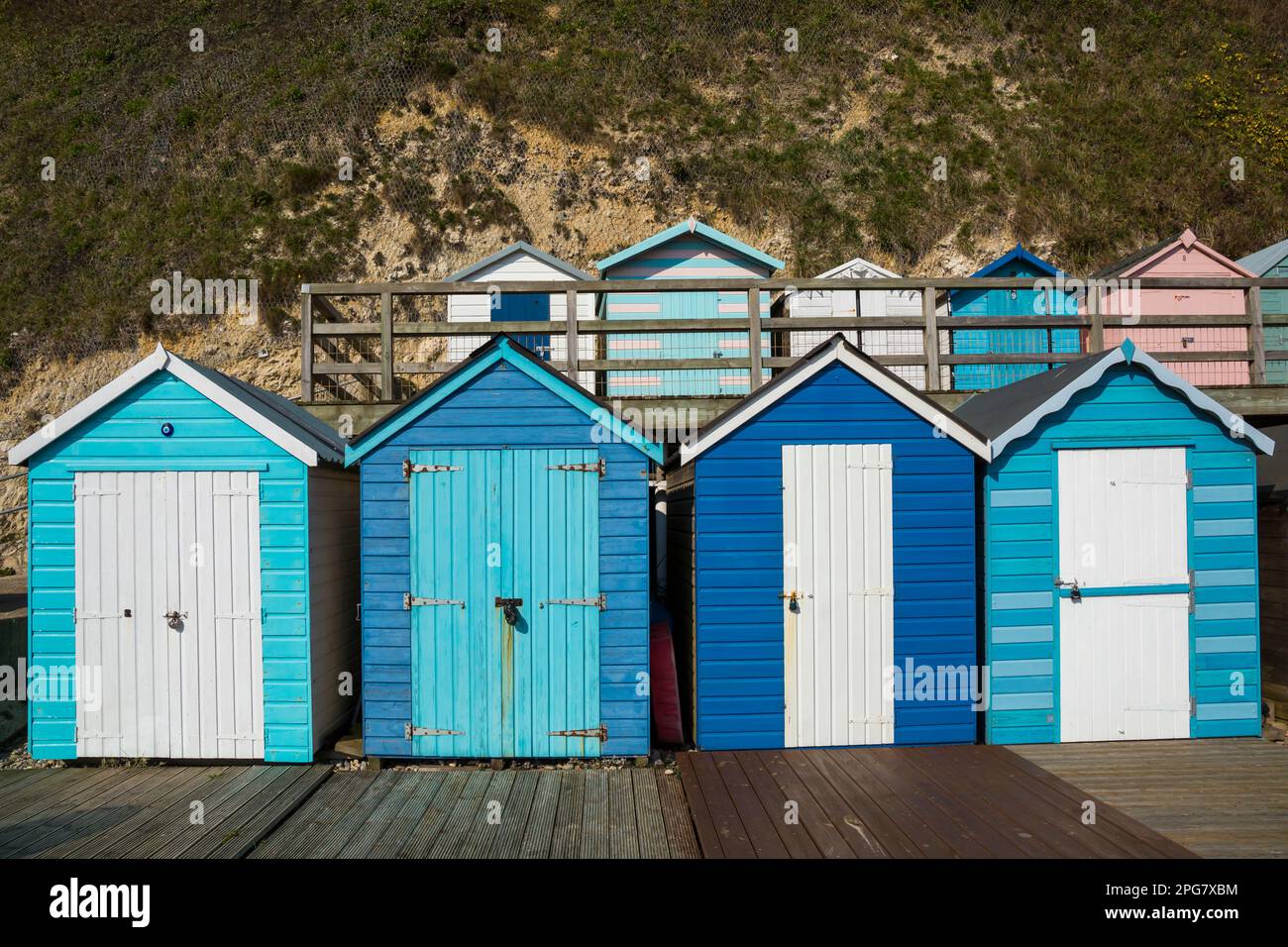 Rows of blue beach huts at base of cliffs at Beer beach, Seaton, Devon ...