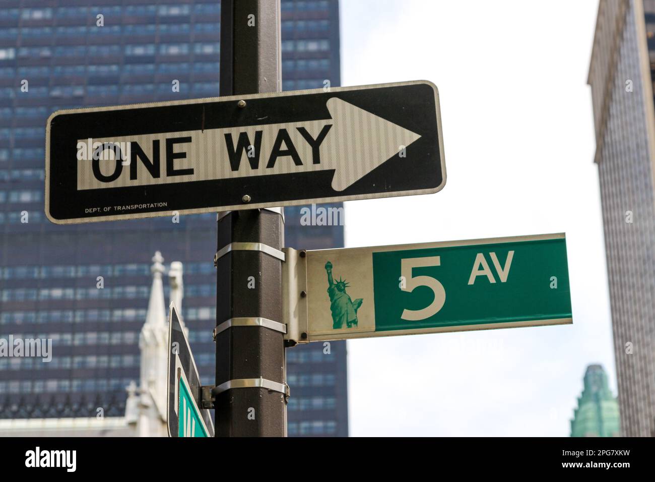 A one-way street sign with the number 5 written on it in front of a row ...