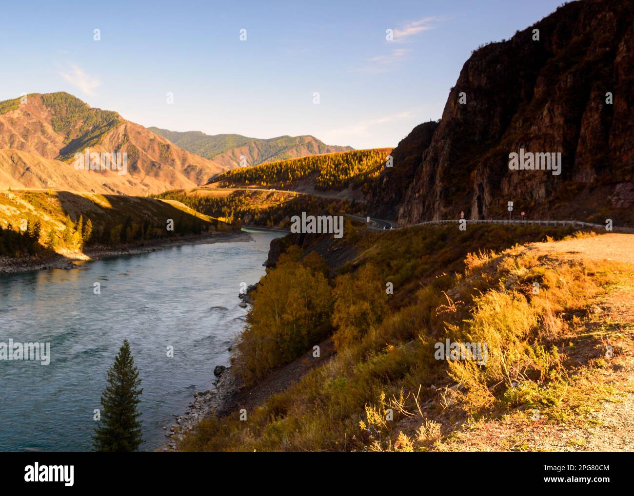 The mountain road Chuisky Trakt goes under a rock in the shade next to ...