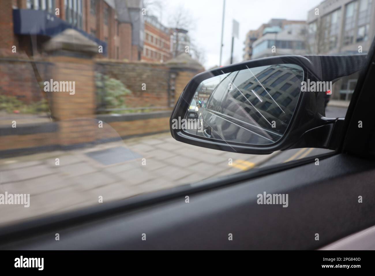 A rear view mirror in a car interior, seen from the driver's seat, as ...