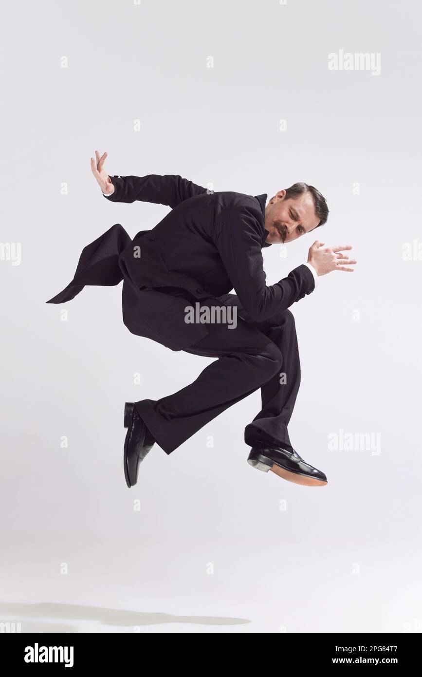 Dynamic portrait of retro man in old-time evening suit dancing crazy ...