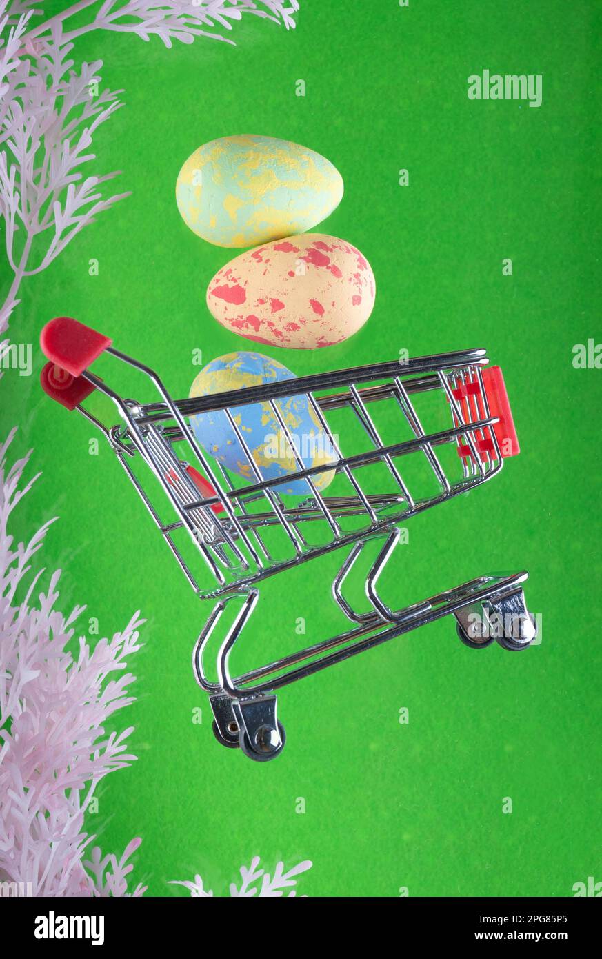 Easter sale. Shopping cart, trolley floating on green backdrop with ...