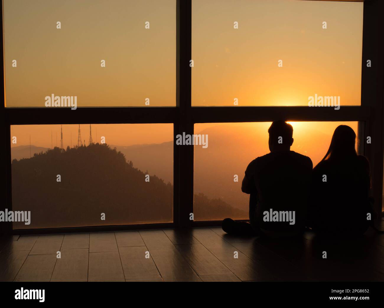 A shot of a couple embracing while looking out a window at the stunning ...