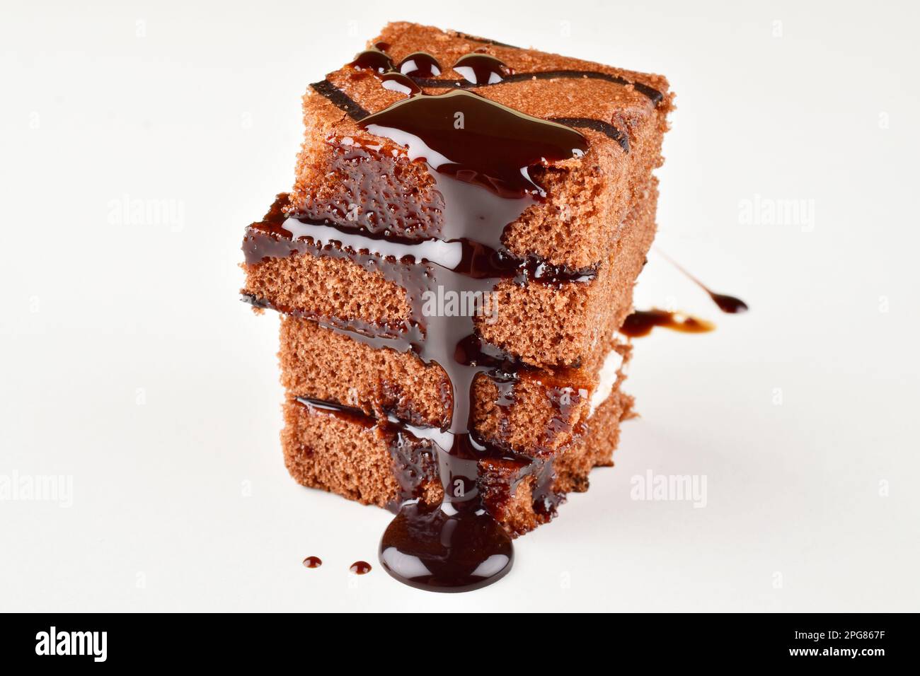 Piece of chocolate cake with choco syrup isolated on white background ...