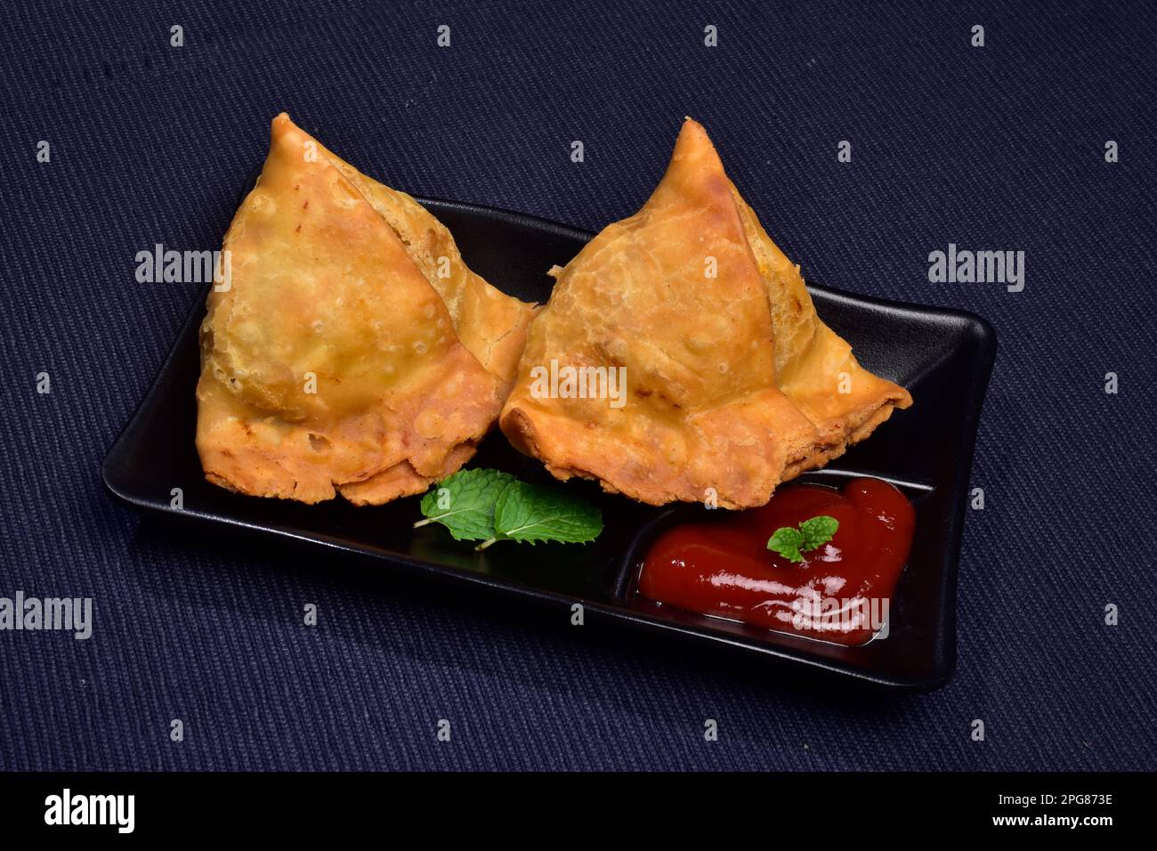 Two samosa in plate served with ketchup Stock Photo - Alamy