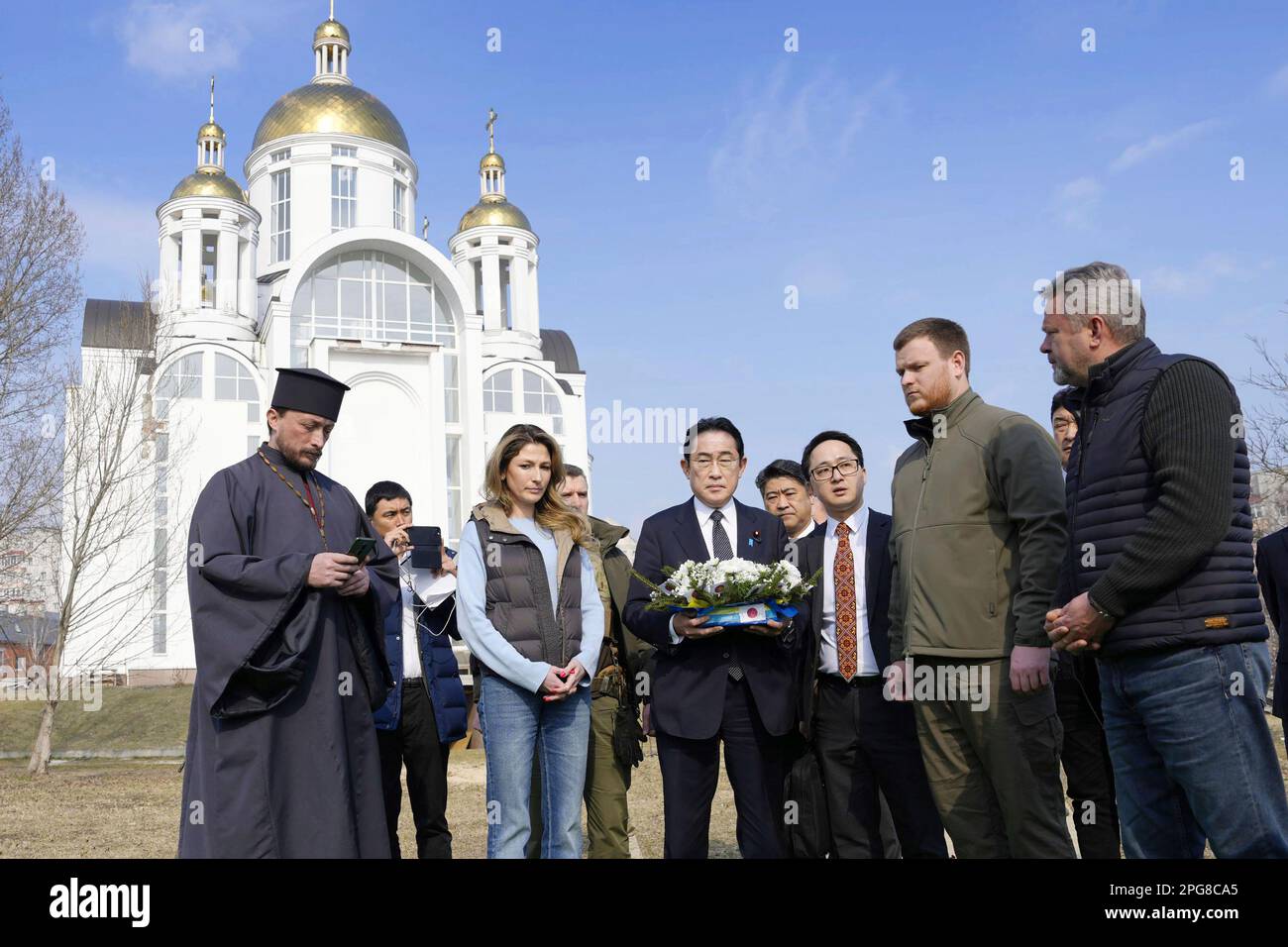 Japanese Prime Minister Fumio Kishida, center, holds the wreath to ...