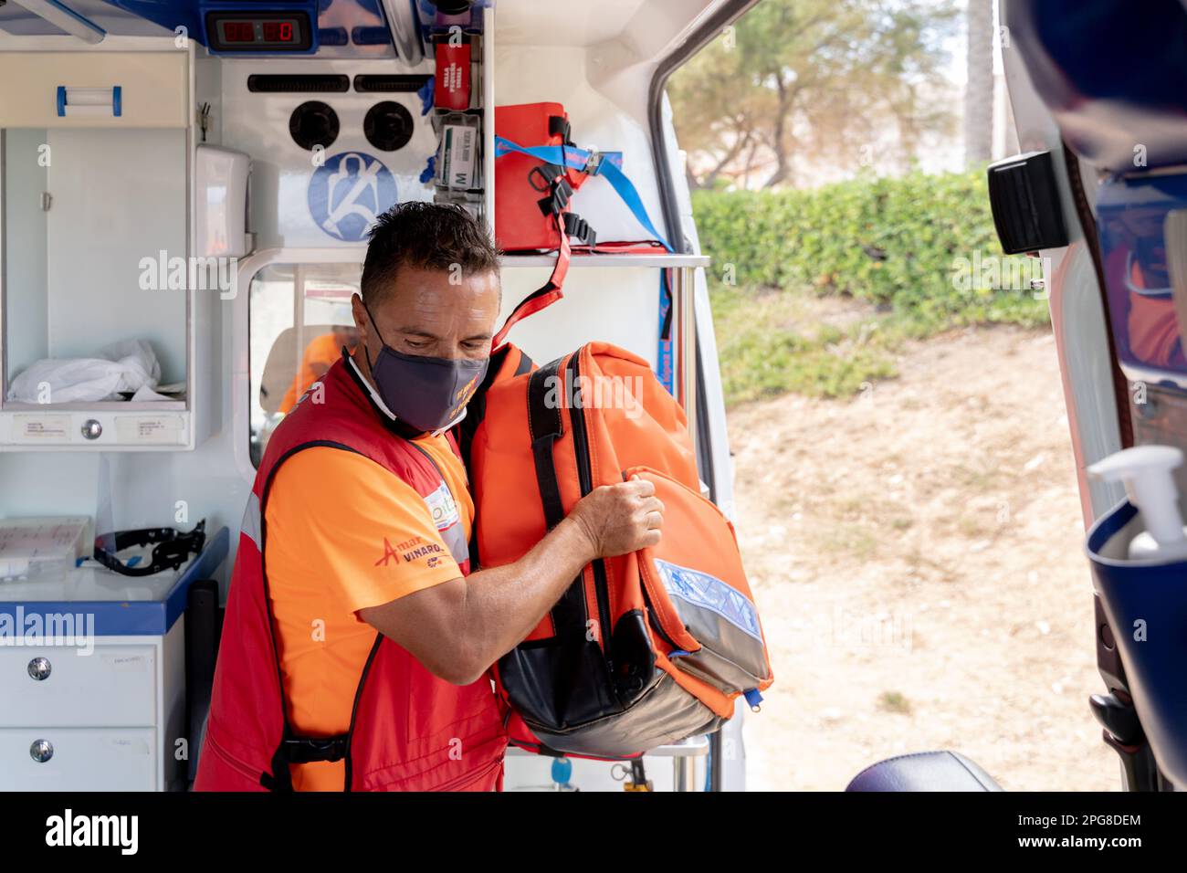Lifeguard with a facial mask carrying a first aid bag out from an ...