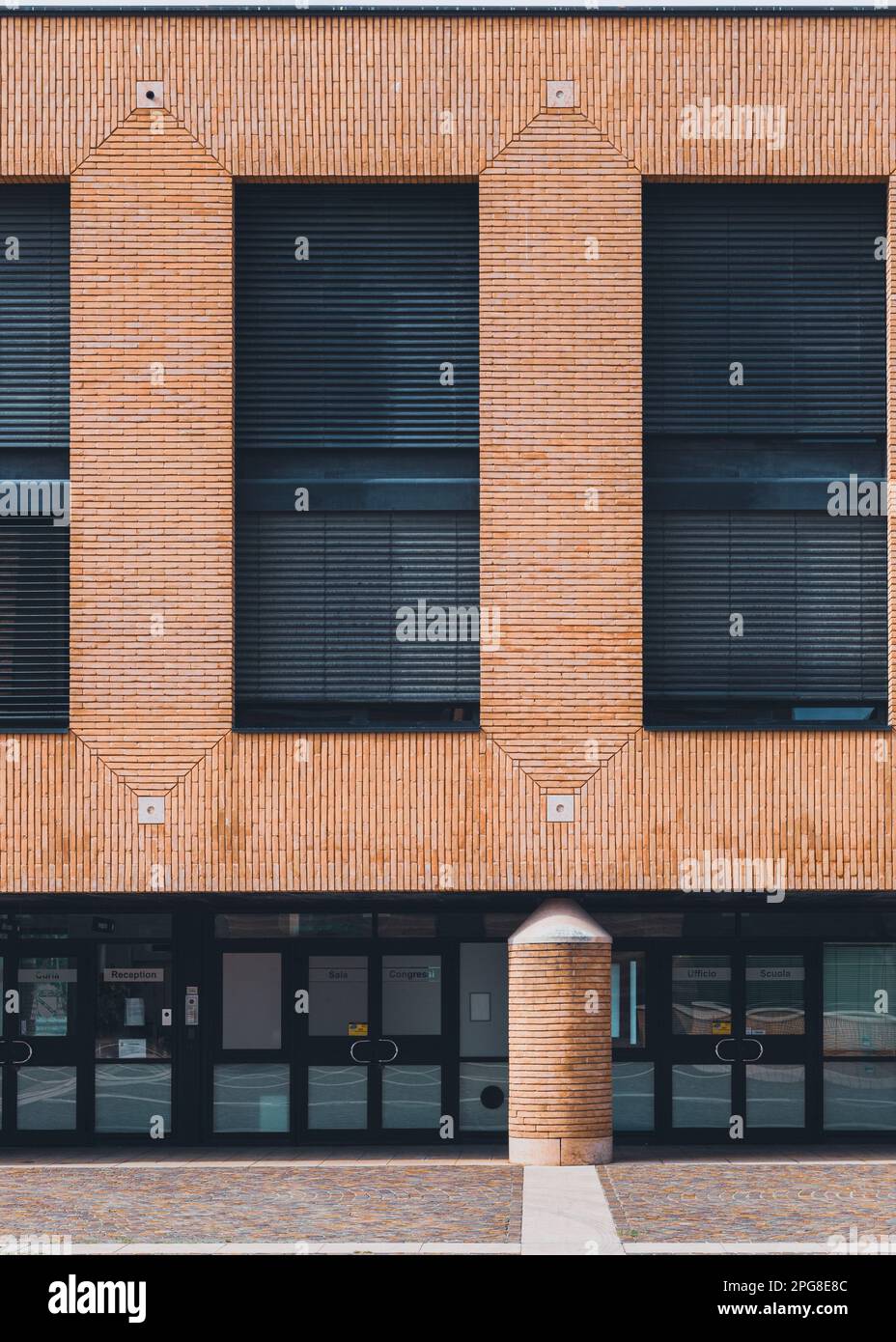 An orange brick building with three large windows Stock Photo - Alamy