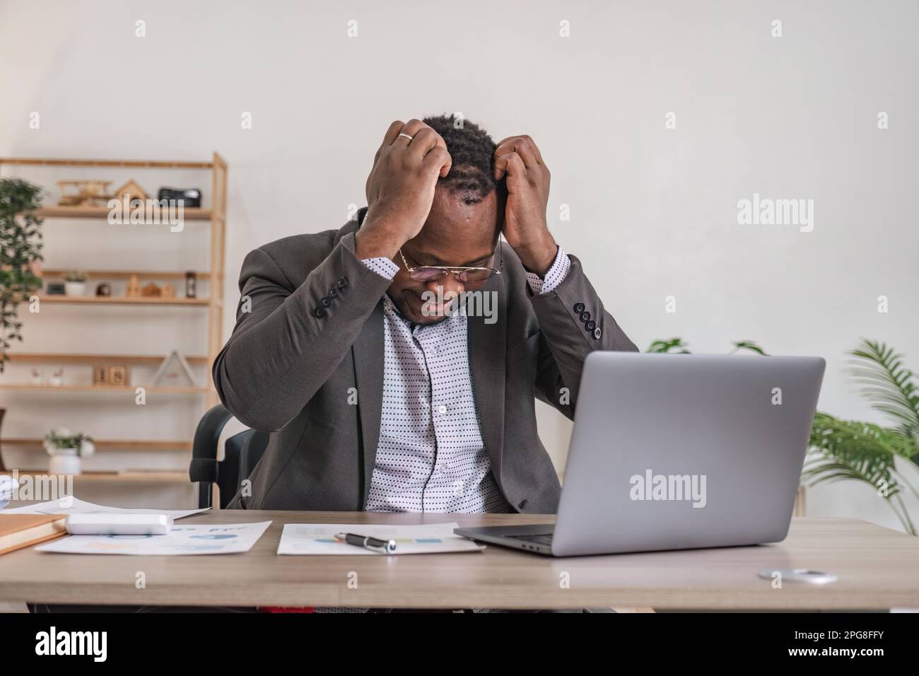 Unhappy black male worker at laptop screen shocked by gadget breakdown ...