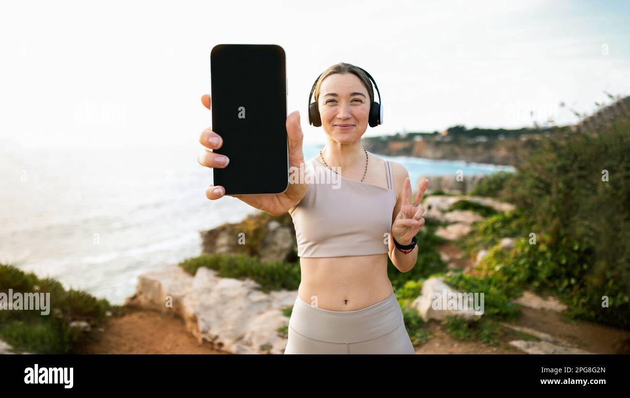 Happy slim millennial european lady in sportswear, wireless headphones ...