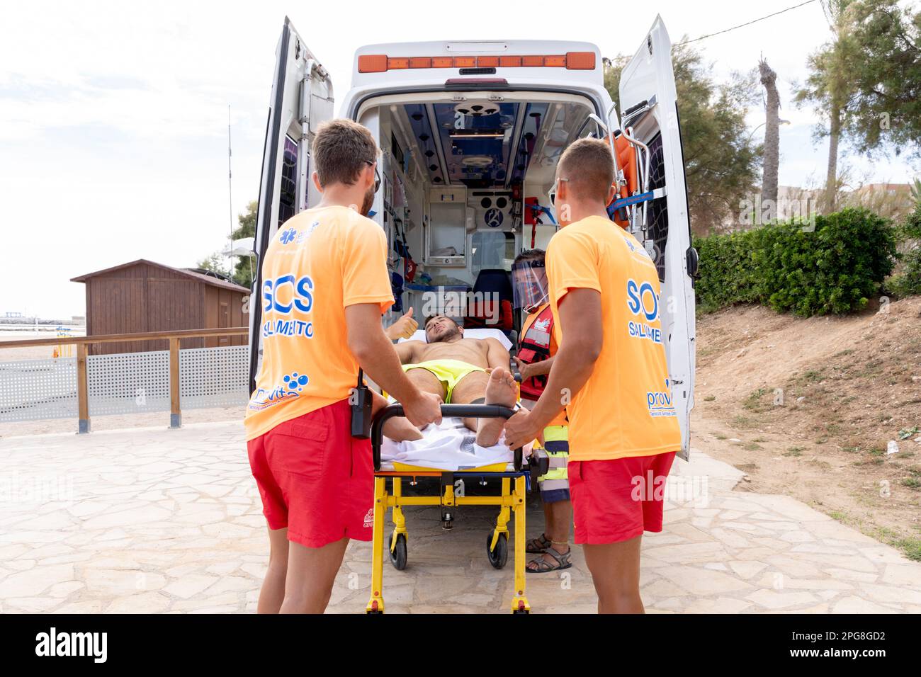 Rear view of a rescue team carrying a patient inside an ambulance Stock ...