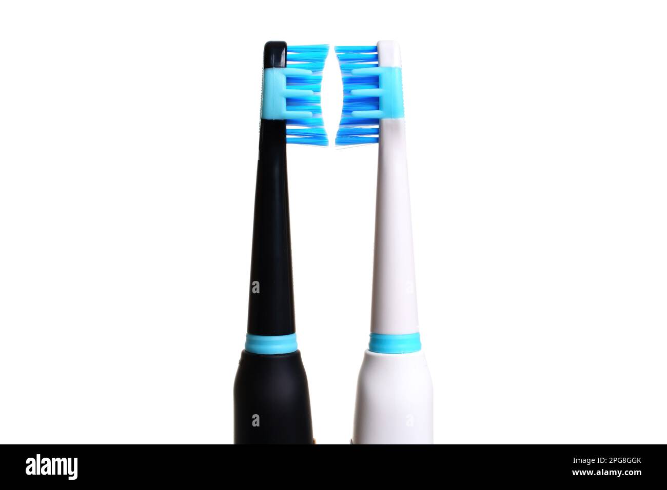 Two electric toothbrushes, one black and one white, with blue bristles ... Two electric toothbrushes, one black and one white, with blue bristles ...
