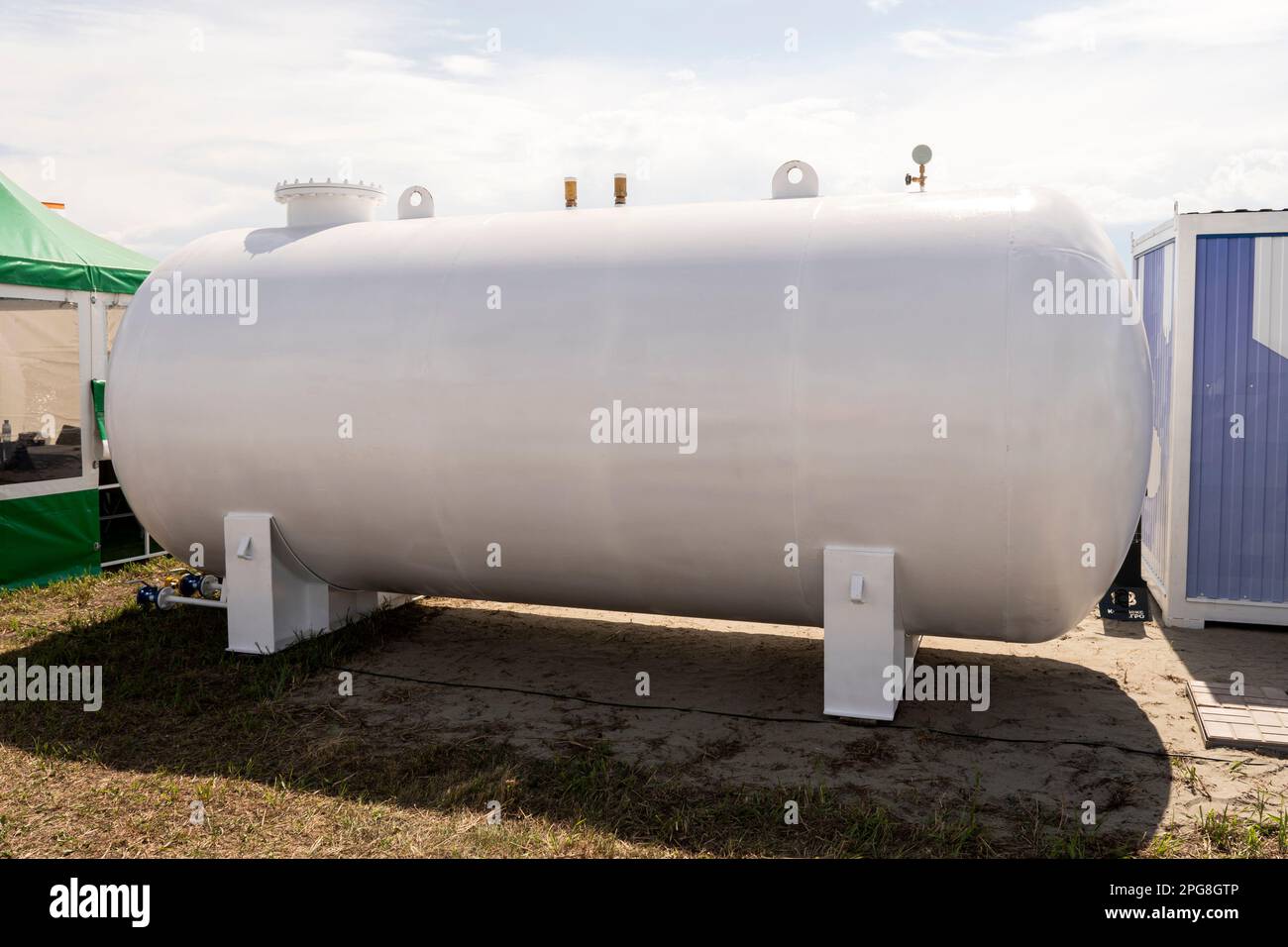 large white liquid storage tank outside. a barrel for fuel or water ...