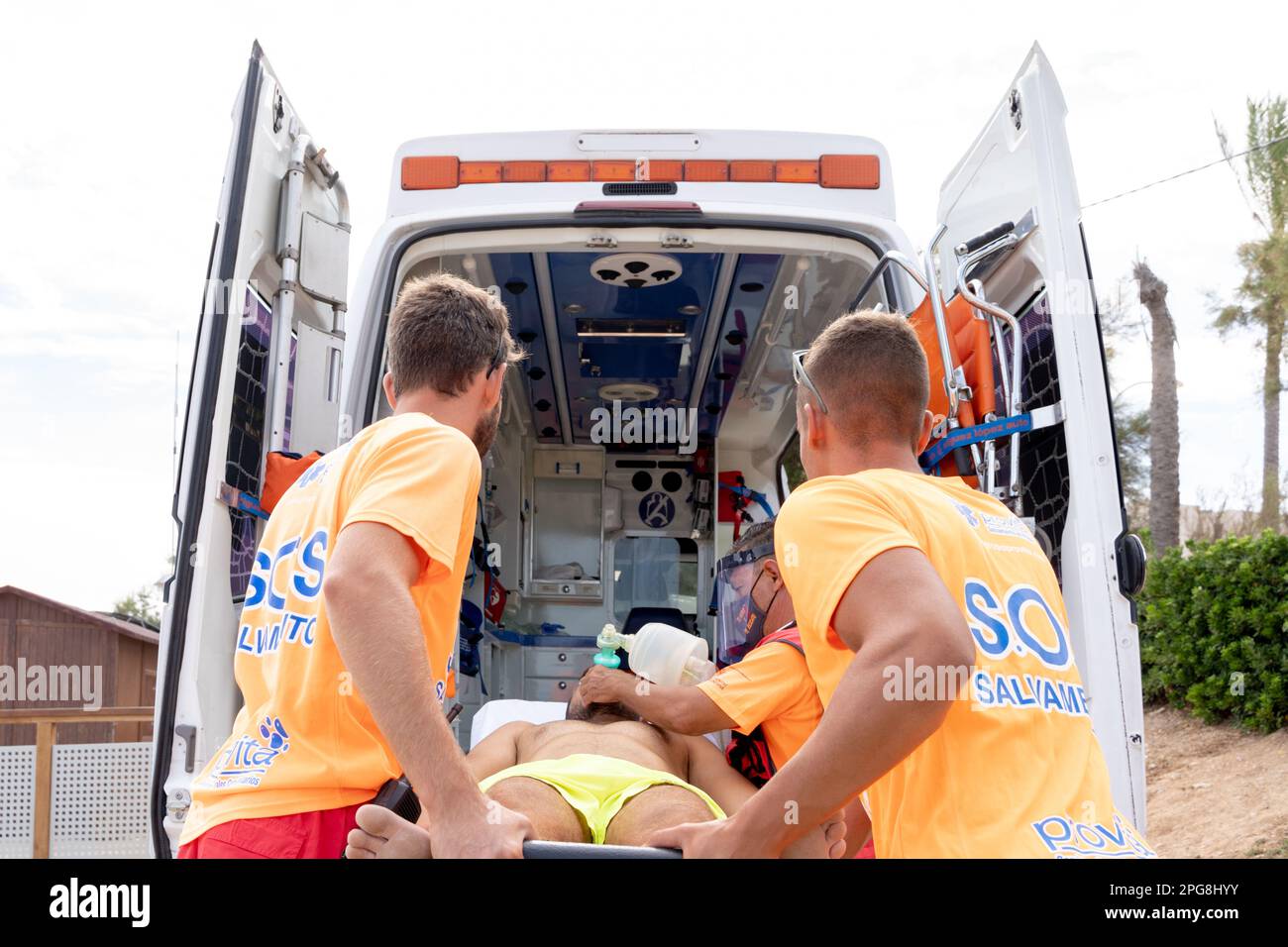 Rear view of Lifeguards team working carrying a patient inside an ...