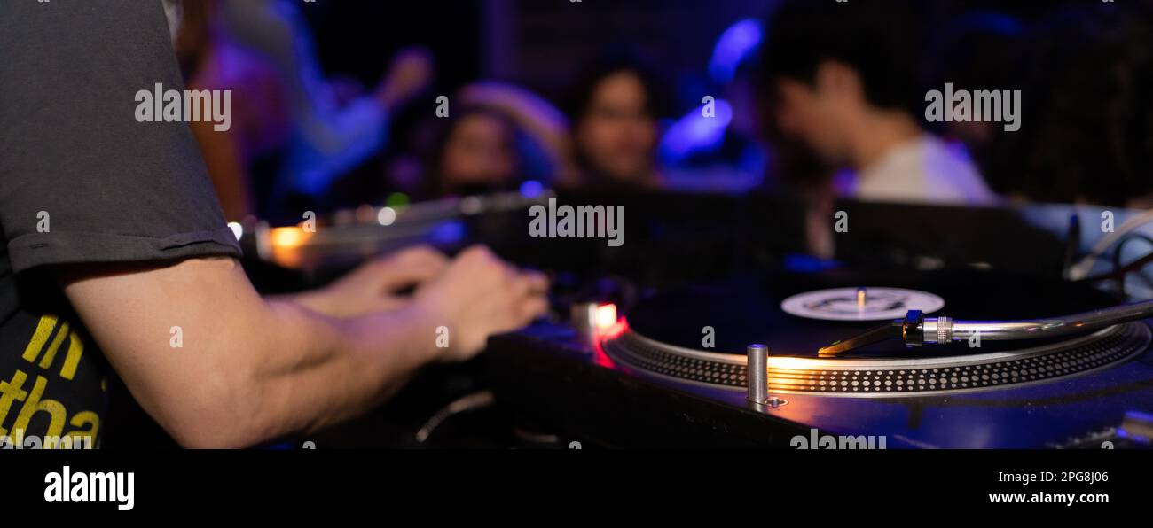 Consular DJ detail with selective focus on turntable while mixing in a ...