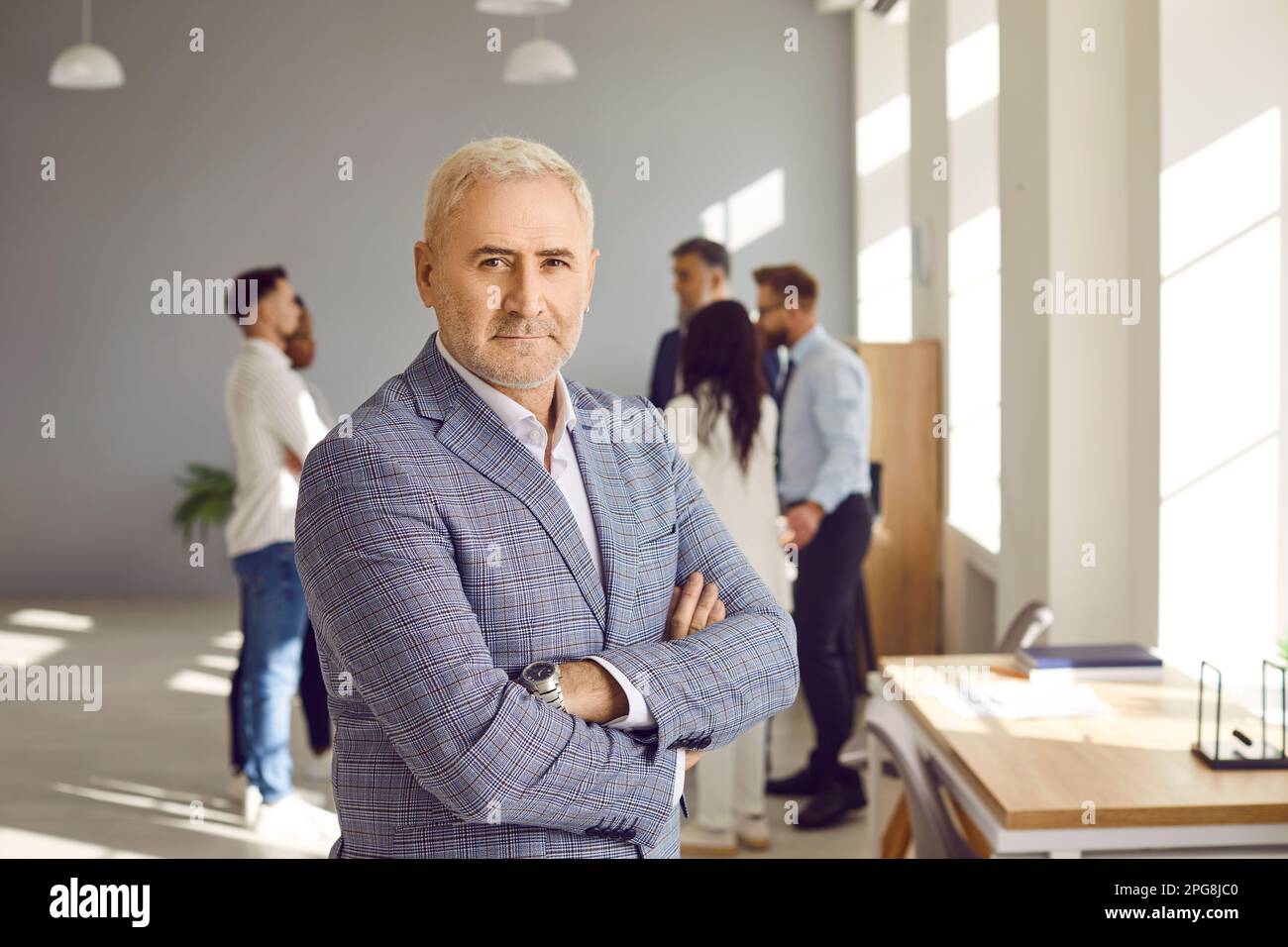 Mature confident business man leader looking at the camera with crossed ...